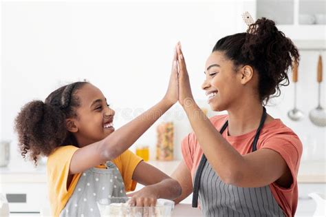 Madre E Hija Negras Alegres Dando Cinco Al Máximo Mientras Cocinan Foto de archivo Imagen de