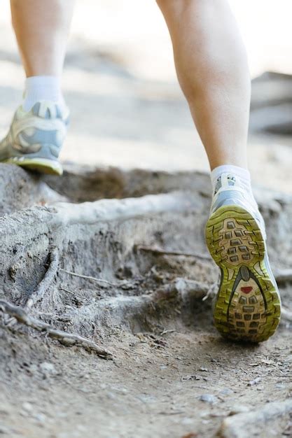 Premium Photo Low Section Of Woman Walking On Tree Root
