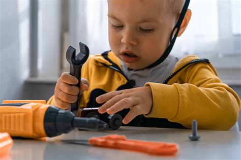 아이들은 집에서 작업 도구를 가지고 놀고 엔지니어가되는 꿈을 꾼다 어린 소년 건축업자 교육 상상력 목적성 개념 아이와 렌치 2 3 살에 대한 스톡 사진 및 기타 이미지