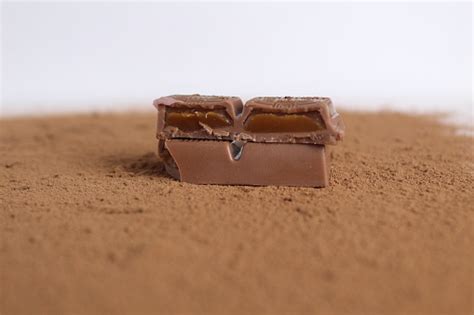 소금에 절인 캐러멜로 채워진 초콜릿은 흰색 배경의 코코아에 놓여 있으며 초콜릿 의 날 표지에는 텍스트와 카피스파스 공간이 있습니다 0명에 대한 스톡 사진 및 기타 이미지