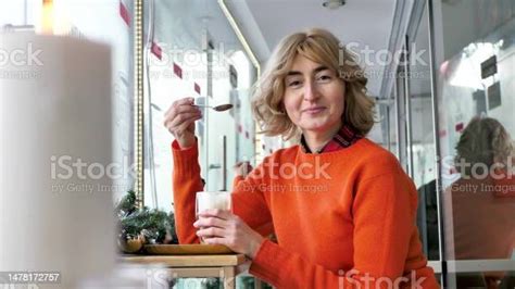 아름다운 여자는 카페에서 투명한 머그잔에서 커피를 마신다 카페에서 새해 장식 겨울에 대한 스톡 사진 및 기타 이미지 겨울