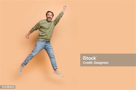 쾌활한 사람의 전신 초상화는 베이지 색 배경에 고립 된 팔을 들어 올리십시오 점프에 대한 스톡 사진 및 기타 이미지 점프 남자 중장년 Istock