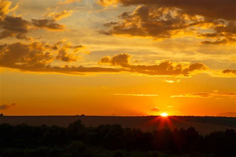 광선과 일몰 오렌지 색상에 아름다운 밝은 장엄한 극적인 저녁 하늘 해질 녘에 천둥구름을 배경으로 태양이 수평선 너머로 빛납니다 0명에 대한 스톡 사진 및 기타 이미지
