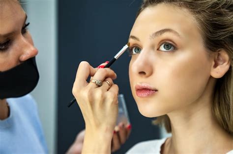 Premium Photo Makeup Artist Doing Professional Make Up Of Young Woman