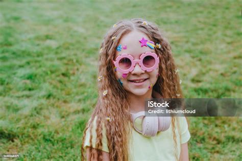 핑크색 안경을 쓰고 얼굴에 스티커를 붙인 귀여운 십대 소녀 10 11세에 대한 스톡 사진 및 기타 이미지 10 11세 Z세대 곱슬 머리 Istock