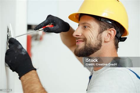개조 작업 후 아파트의 소켓을 교체하는 유니폼을 입은 전문 전기 기술자를 웃고 있습니다 전기공에 대한 스톡 사진 및 기타 이미지 전기공 가정 생활 직업 Istock