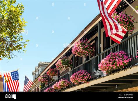 American Flags Hang Off A Second Floor Balcony Of A Historic Building