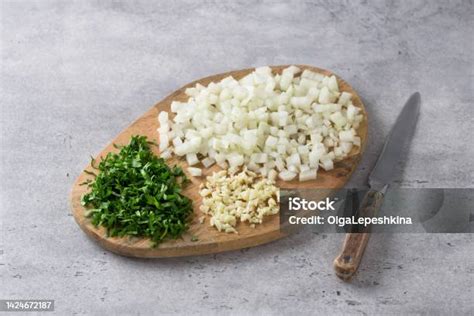 잘게 잘린 야채가있는 나무 보드 양파 파슬리 및 마늘을 칼로 회색 질감의 배경에 올려 놓은 상단보기 수제 음식 요리 날것에 대한 스톡 사진 및 기타 이미지 Istock