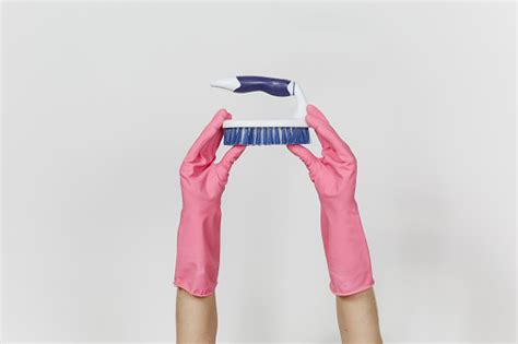 핑크 장갑 가로 흰색 배경에 고립 된 파란색 요소와 청소에 대 한 하드 섬유와 흰색 브러쉬를 보유 하 고 여성 손을 닫습니다 청소 공급 개념입니다 광고에 대 한 공간을 복사