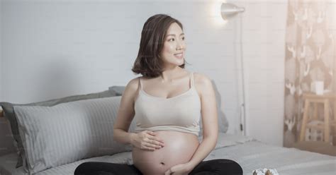 아름 다운 아시아 임신 한 여자는 침대에 앉아 그녀의 배를 만지고 사진 Unsplash의 임신한 이미지