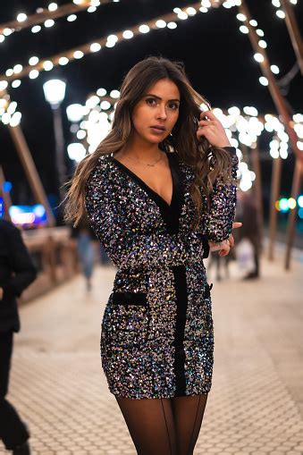 크리스마스 라이프 스타일 갈색 머리 백인 소녀 에 A 유행 드레스 와 스팽글 과 블랙 신발 발 뒤꿈치 도시의 크리스마스 조명에서 즐기는 12월에 대한 스톡 사진 및 기타