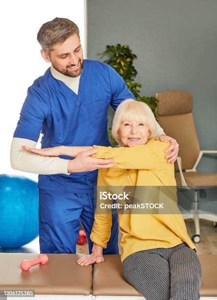 그의 물리 치료사와 함께 치료를 하는 동안 수석 환자 의료 센터에서 재활 25 29세에 대한 스톡 사진 및 기타 이미지 25 29세 2명 70 79세 Istock