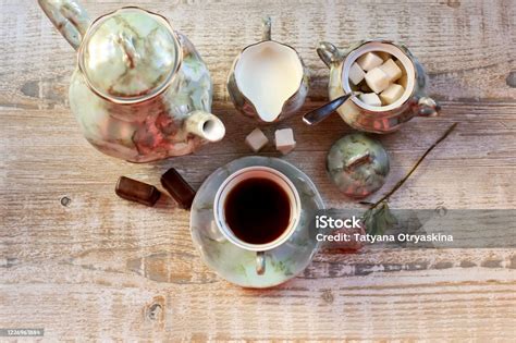 얇은 크레이프 사워 크림 설탕 우유 주전자와 함께 햇빛과 그림자가 있는 가벼운 질감의 나무 테이블에 찻잔이 제공됩니다 휴식 휴일 주말의 개념 0명에 대한 스톡 사진 및 기타