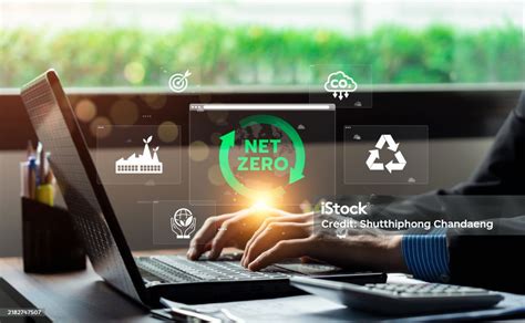 Net Zero 및 Sustainability 아이콘이 있는 노트북에서 작업하는 비즈니스 전문가 탄소 중립 재생 에너지 및 친환경 관행에 대한 기업의 약속을 강조합니다 0에