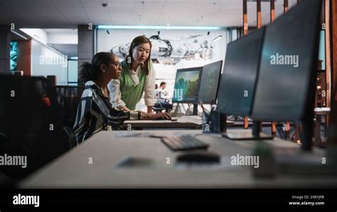 Black Female Game Developer Using Desktop Computer With 3d Modelling Software And Talking To