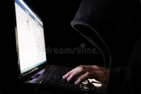 Hacker Man In Black Hood And Mask With Computer Laptop Hacking System In Digital Intruder Cyber