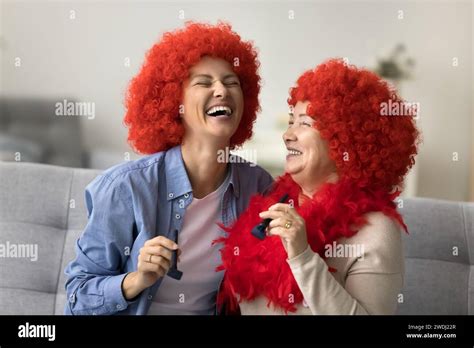 Excited Mom And Adult Daughter Wearing Clown Wigs Having Fun Stock