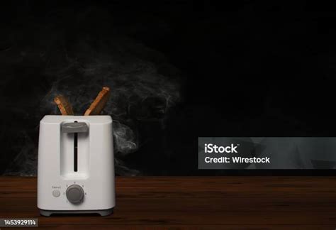 Closeup Shot Of Two Burnt Pieces Of Toasts In A Smoking Toaster With