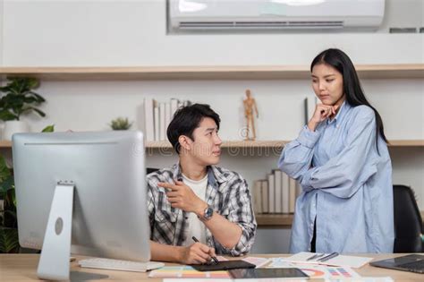 Ux And Ui Designers Collaborating A Focused Discussion About Design Elements In A Modern Office