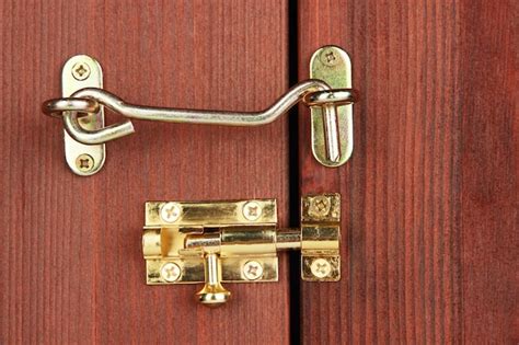 Premium Photo Metal Hook And Deadbolt In Wooden Door Closeup
