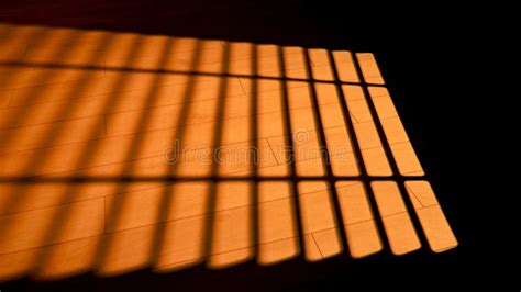 Warm Yellow Reflection Of Window Jalousie Blinds On The Wooden Floor