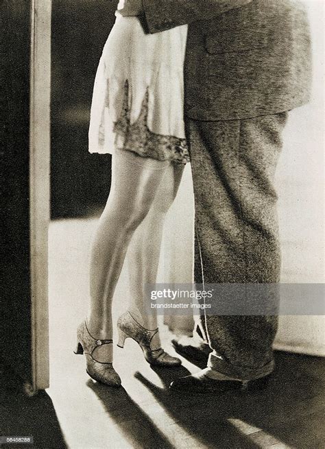 Woman In Her Negligee And Stockings And Man In His Suit Standing At