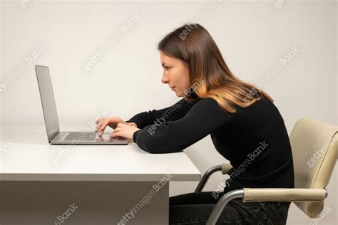 Young Woman In Slouching Position Sitting In Office Room Working With