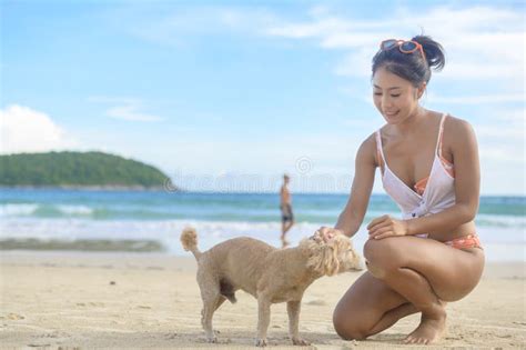 Young Beautiful Woman In Bikini With Her Dog Enjoying And Relaxing On