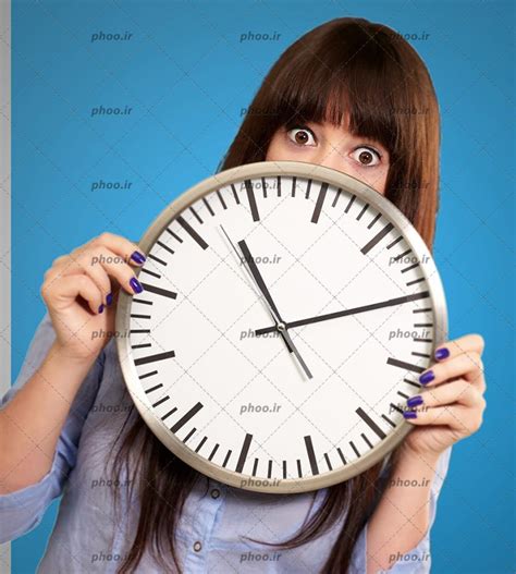 عکس زن با یک ساعت بزرگ در مقابل صورت در پس زمینه آبی عکس با کیفیت و