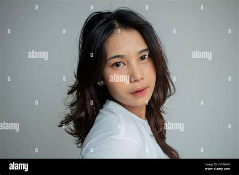 Close Up Of Young Asian Face Without Makeup With Long Black Hair Flowing With Flat Face Pose In