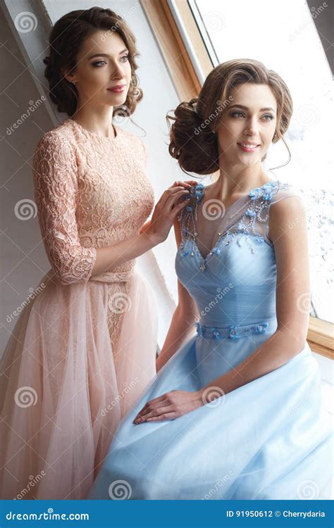 Two Beautiful Twins Young Women In Luxury Dresses Pastel Colors Stock