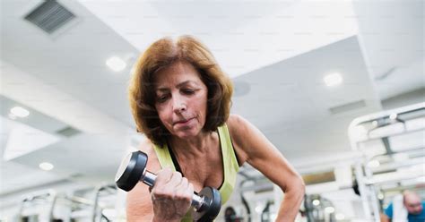 체육관에서 운동복을 입은 노인 여성이 웨이트로 운동하고 있다 손을 닫습니다 사진 Unsplash의 운동 이미지