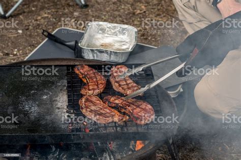 캠프 파이어에서 주철 그릴 접시에 굽는 쇠고기 스테이크 캠프 파이어 요리 야외 바베큐 남자에 대한 스톡 사진 및 기타 이미지