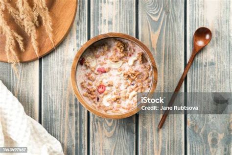 곡물 그라 놀라 딸기 및 견과류로 채워진 나무 그릇에 우유가 부어졌습니다 작은 이삭 소박한 나무 표면에 숟가락 0명에 대한 스톡 사진 및 기타 이미지 Istock