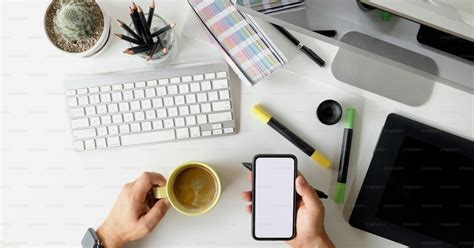 크리에이티브 아티스트 작업 공간에서 빈 화면 휴대폰을 들고 있는 그래픽 디자이너 상위 뷰 작업장 사진 Unsplash의