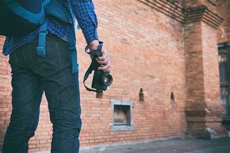 블루 셔츠와 카메라와 배낭 오래 된 벽돌 벽 근처에 서 청바지를 입고 젊은 아시아 남자 거리에 대한 스톡 사진 및 기타 이미지 거리 건강한 생활방식 관광객 Istock