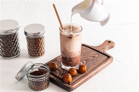 주전자에서 나온 우유 한 줄기를 얼음처럼 차가운 커피 한 잔에 붓습니다 커피를 저장하기위한 캔 맛있는 음료의 준비 라떼에 대한 스톡 사진 및 기타 이미지 Istock