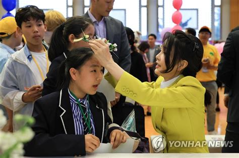 어린이에게 꽃 화환 씌워 주는 김건희 여사 연합뉴스