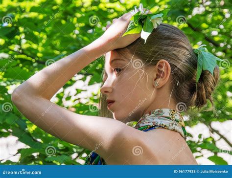 A Young Girl In A Dress With Nude Backs Worth In The Foliage In The