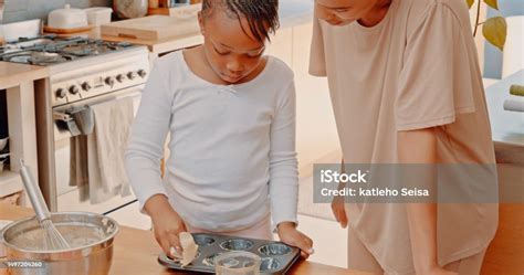 집 부엌에서 쿠키 음식 또는 케이크를 굽는 것을 돕는 어머니 또는 소녀 제빵사를 준비하십시오 엄마 교육 또는 어린 아프리카 아이 기름 기름 머핀 트레이 집에서 요리 기술을