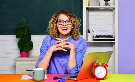 Teacher Or University Professor Sitting At Desk In Classroom Having
