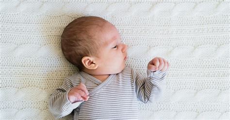 스트라이프 옷을 입은 귀여운 갓 태어난 아기가 침대에 누워 있다 클로즈업 사진 Unsplash의 꼬마 이미지