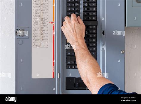 Resetting Tripped Breaker In Residential Electricity Power Panel Male