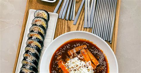 Flavorsome K 푸드 간장 고명 김밥 나무 쟁반 대두 떡 떡볶이 맛있는 매운 매운 요리 먹음직스러운 문화 요리 미식가 미식가를 위한 서빙