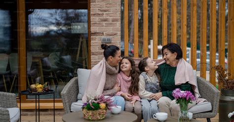 어머니와 할머니가 가을에 안뜰에서 야외에서 담요에 싸여 앉아 있는 행복한 두 자매 사진 Unsplash의 가족 이미지