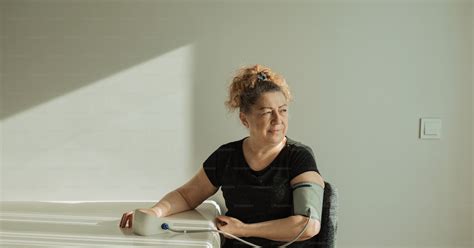 그녀의 손에 전기 장치를 가진 침대에 앉아있는 여자 사진 Unsplash의 고혈압 이미지