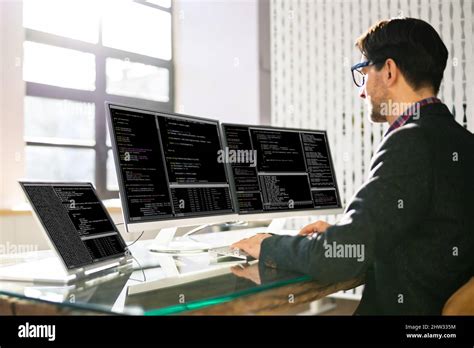 Computer Programmer Writing Program Code On Computer In Office Stock