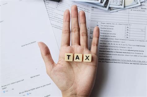 Tax Words On Palm Hands Against The Tax Forms Premium Photo