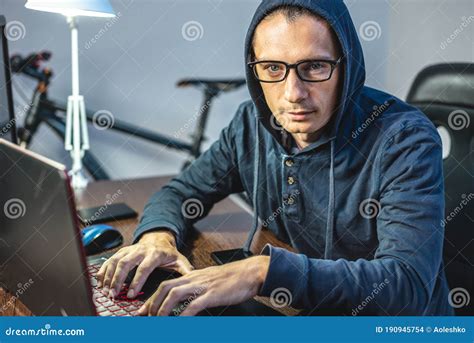 Hacker In The Hood Is Programming Virus Code At The Keyboard For The Laptop Internet Fraud And