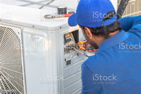 전문 전기 기술자는 건물의 지붕 상단에 있는 공기 조화 기의 무거운 단위를 고정 하 고 파란색 유니폼과 머리 캡을 착용 에어컨에 대한 스톡 사진 및 기타 이미지 Istock